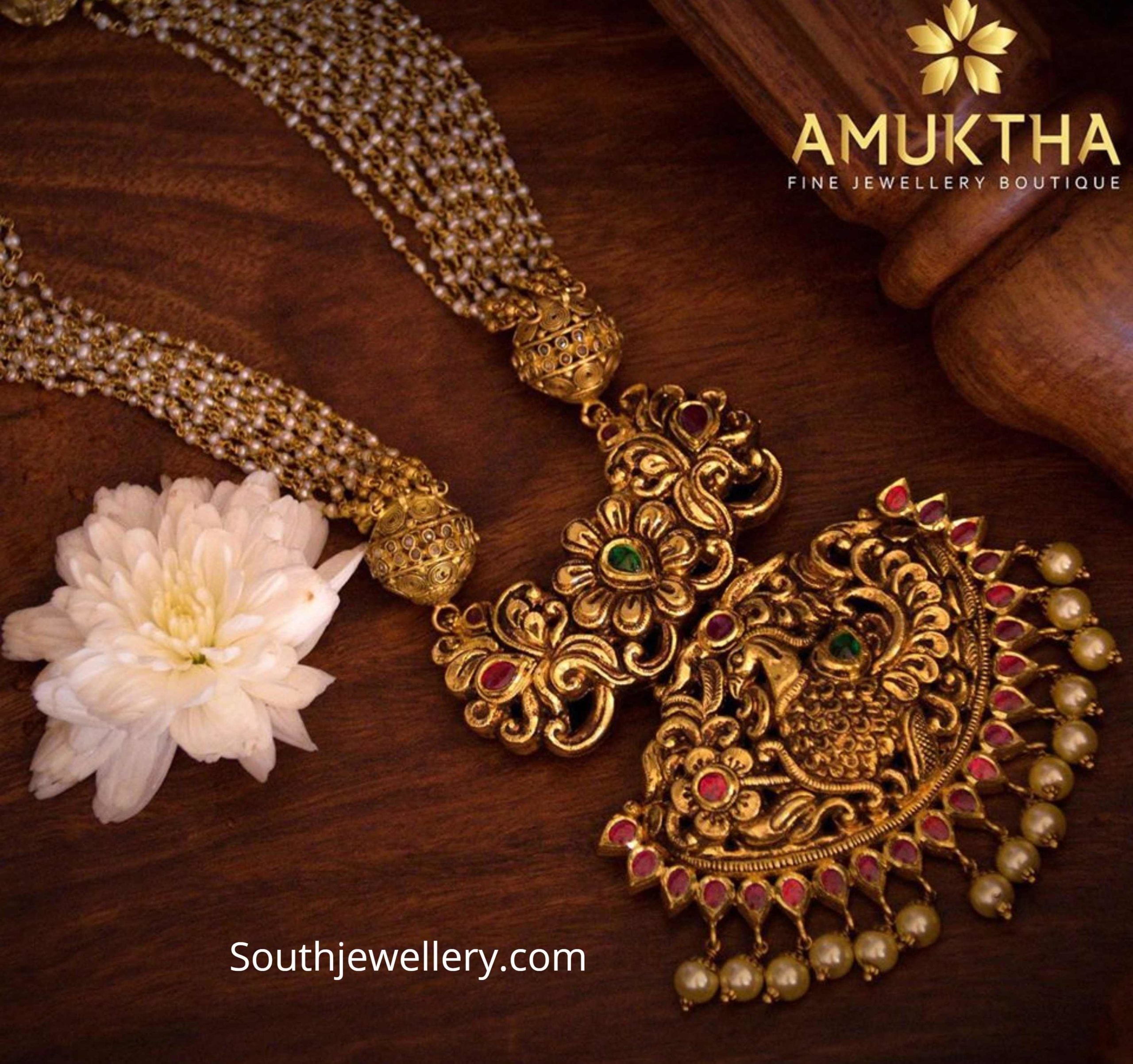 Multi string pearl necklace with gold nakshi peacock pendant
